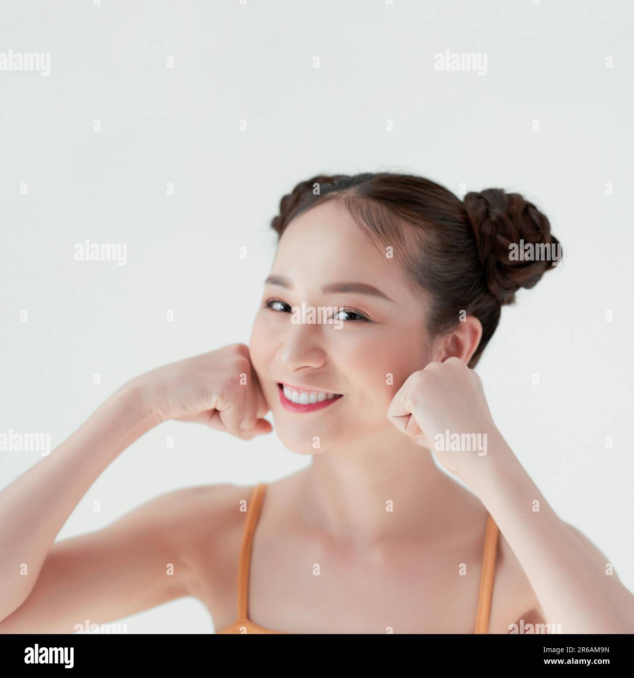 Modern playful girl with two hair buns smiling looking up dreamily ...
