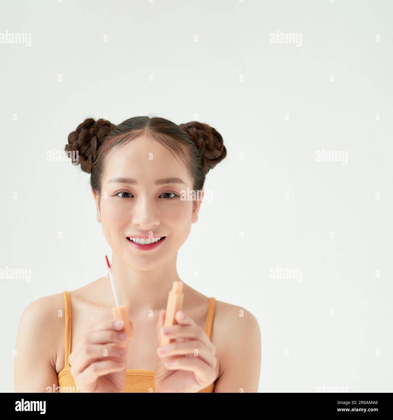Amazing buns-hairstyle girl doing lips makeup Stock Photo - Alamy