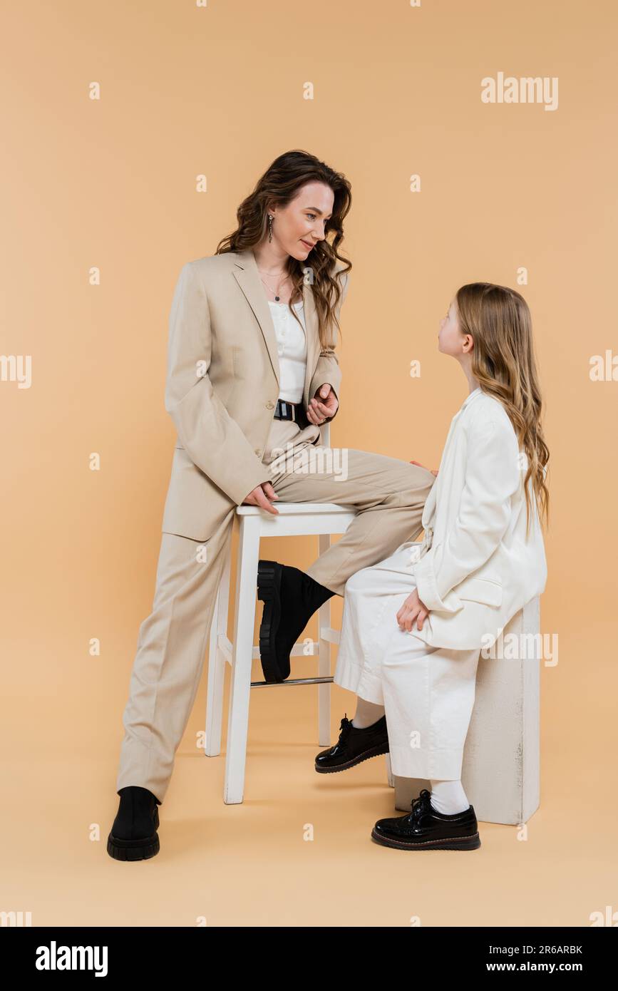 corporate mom and daughter in suits, woman sitting on high chair and ...