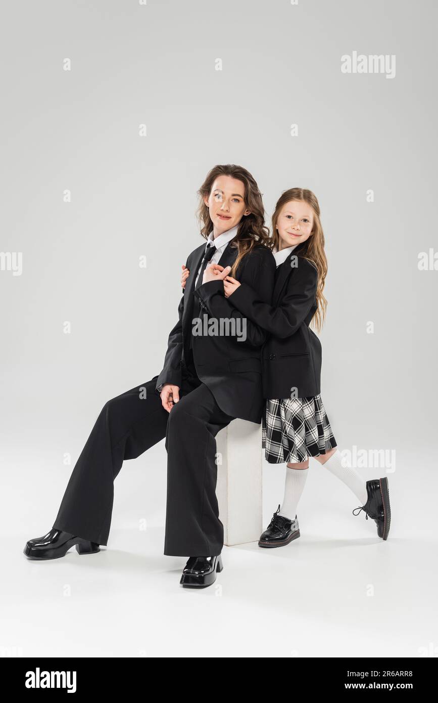 happy girl hugging working mother, businesswoman sitting on concrete ...