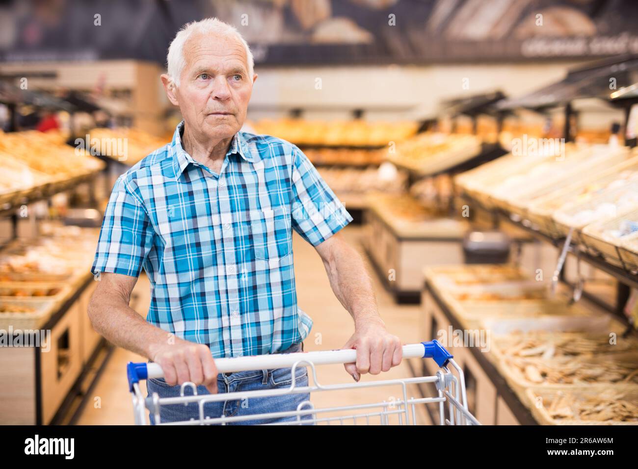 elderly man chooses bread and pastries in the supermarket Stock Photo ...
