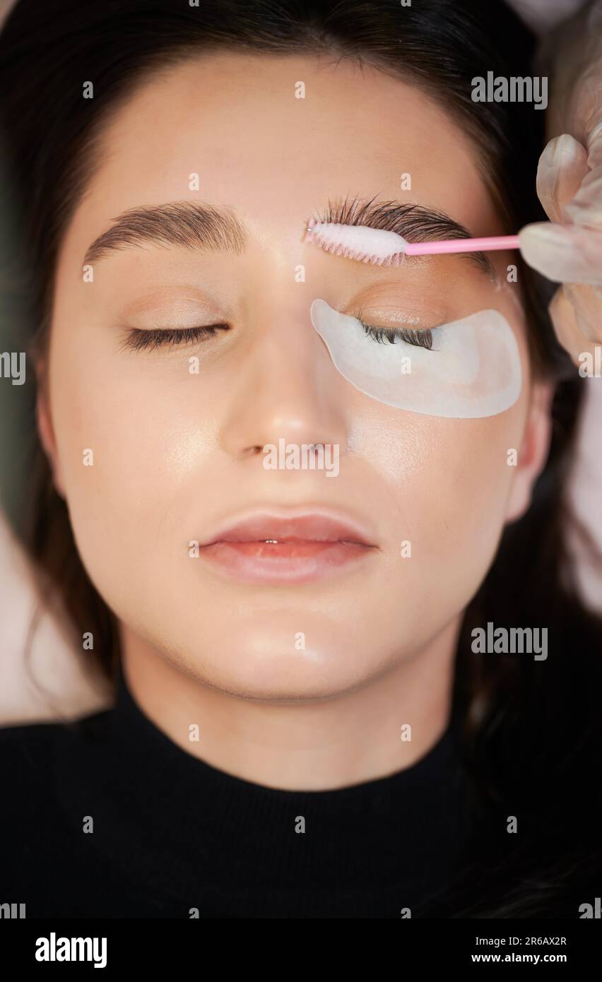 Woman with eye patch under lower eyelid keeping eyes closed while ...