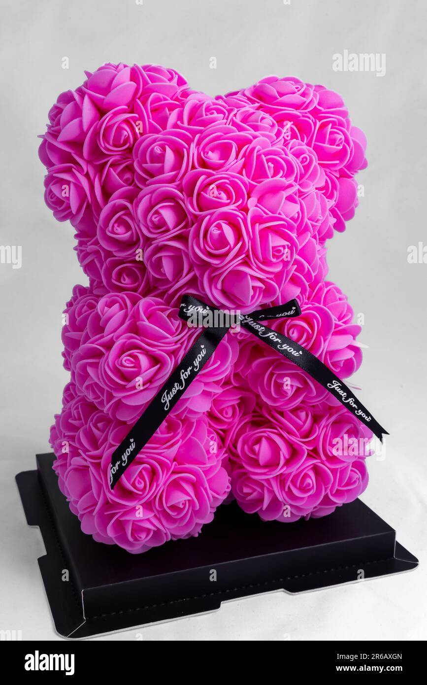 A plush teddy bear made from pink roses, sitting in a bright and ...