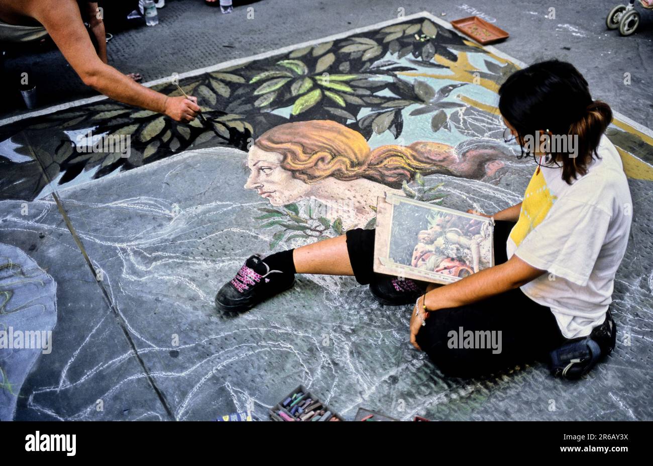 Two street artists painting Boticelli's The birth of Venus, in the ...