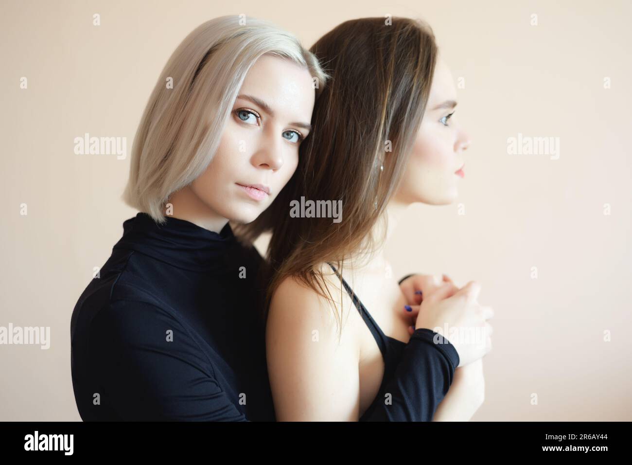 View of two young women on a light background Stock Photo - Alamy