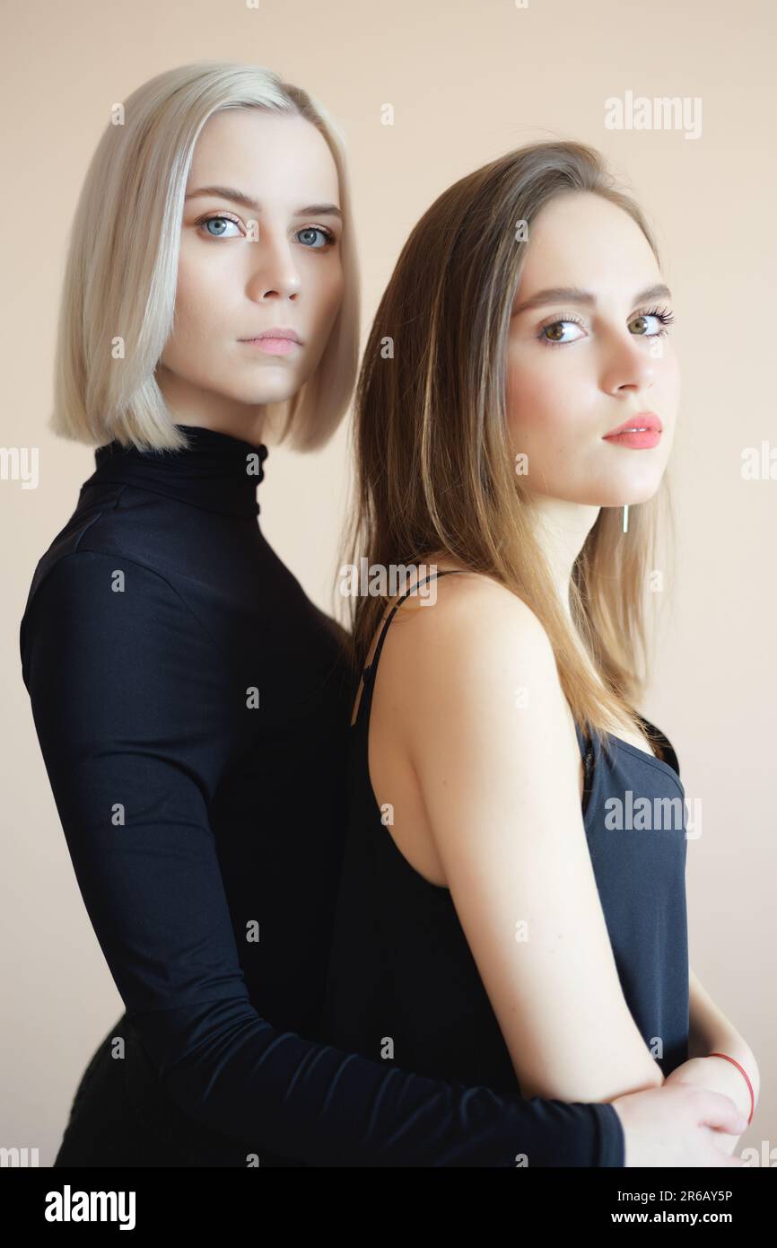 View of two young women on a light background Stock Photo - Alamy