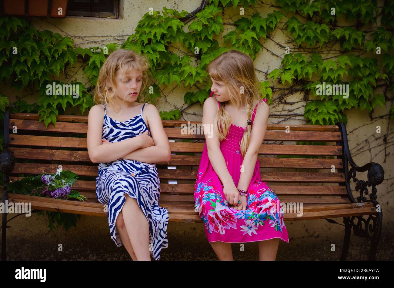 two blond girls relaxing in the bench and speaking together Stock Photo ...