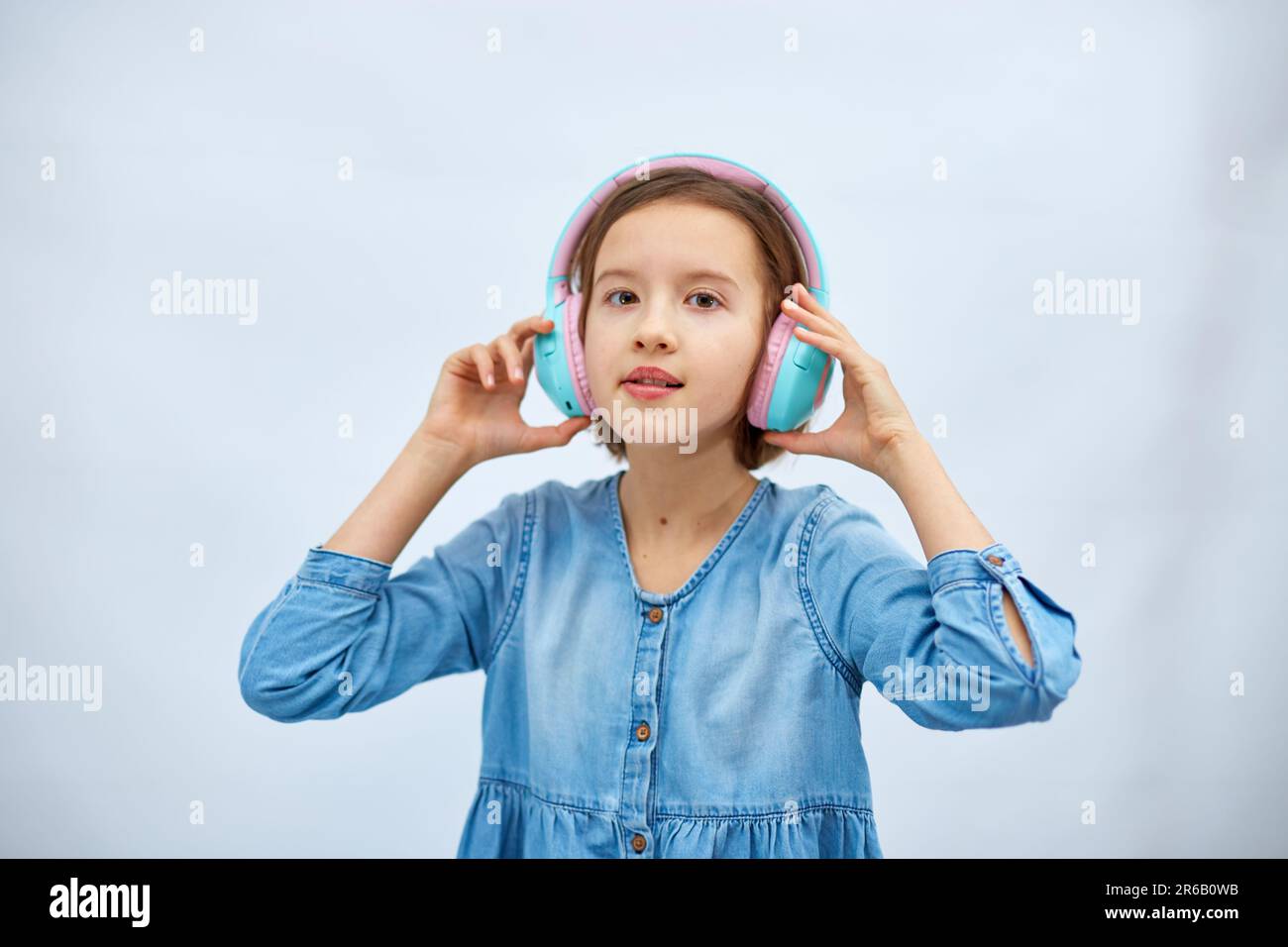 Girl teenager in casual denim dress listening to music in headphones on ...