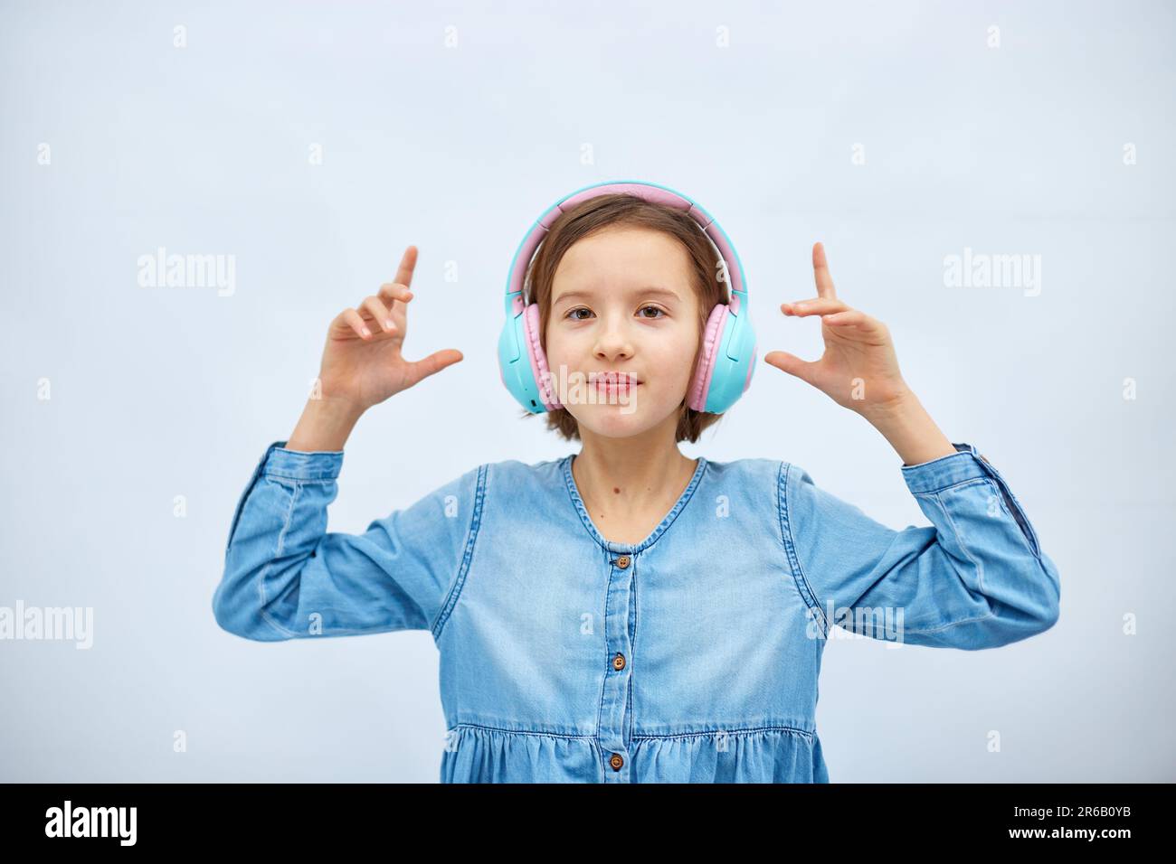 Girl teenager in casual denim dress listening to music in headphones on ...