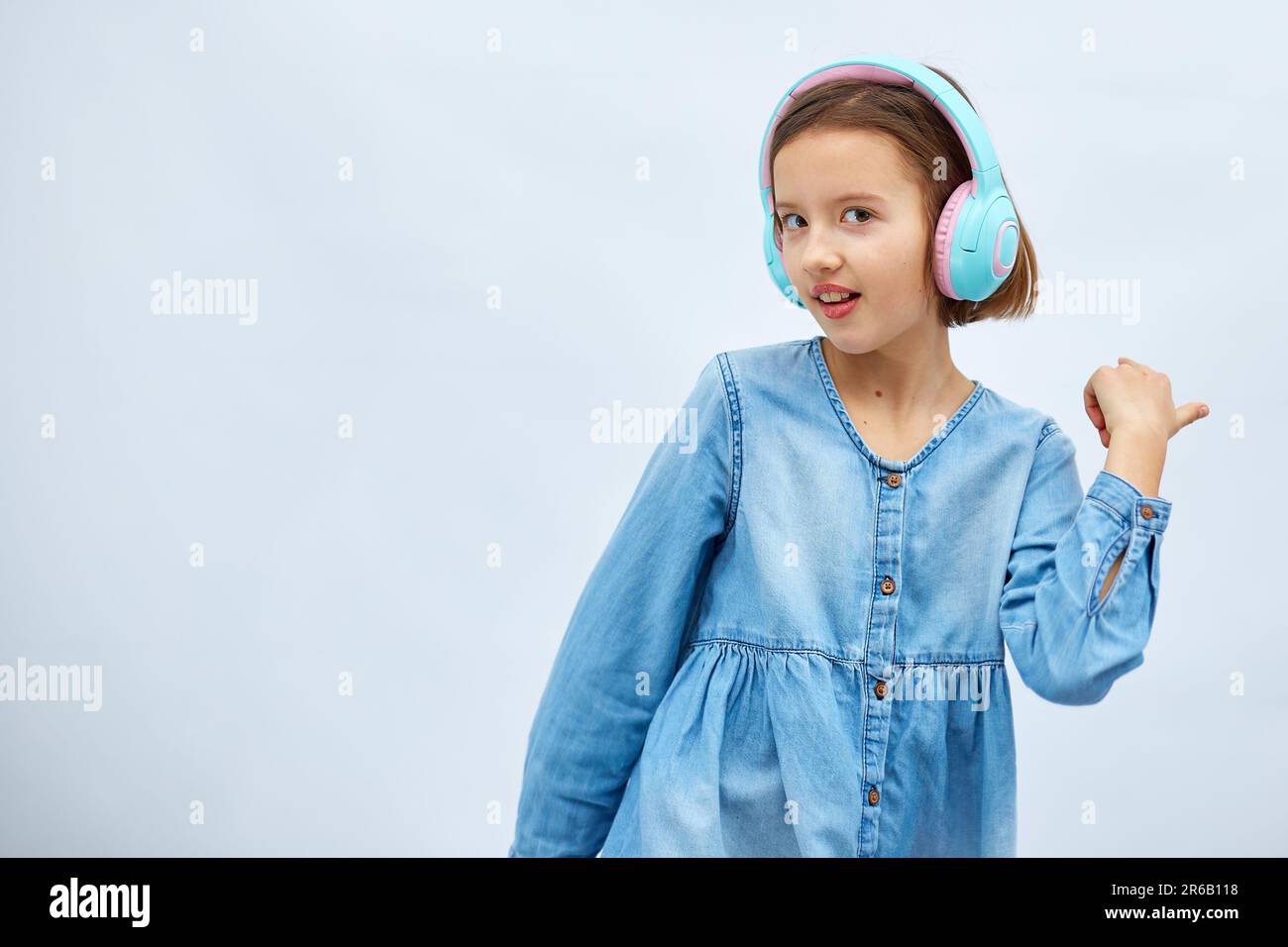 Girl teenager in casual denim dress listening to music in headphones on ...