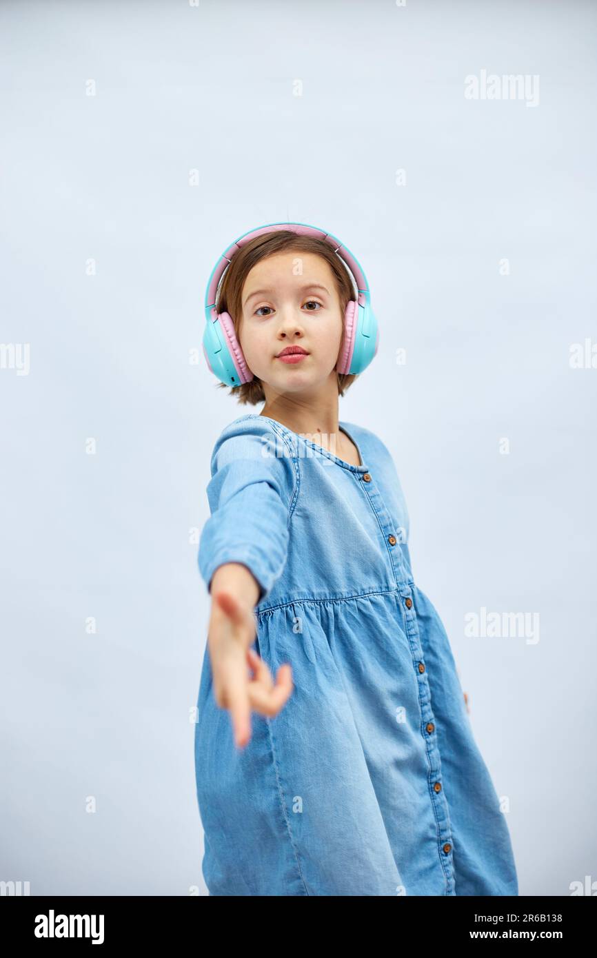Girl teenager in casual denim dress listening to music in headphones on ...