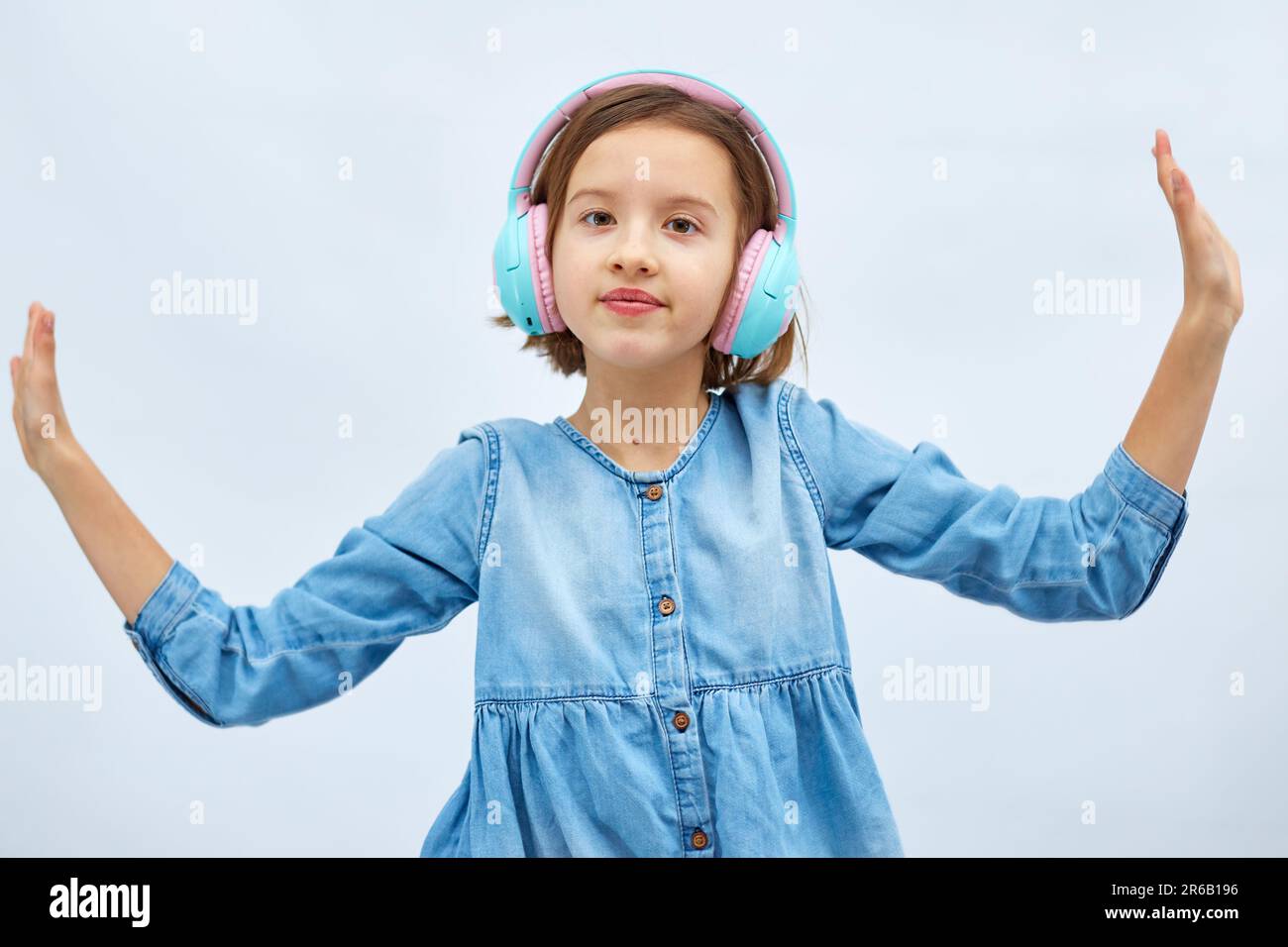Girl teenager in casual denim dress listening to music in headphones on ...