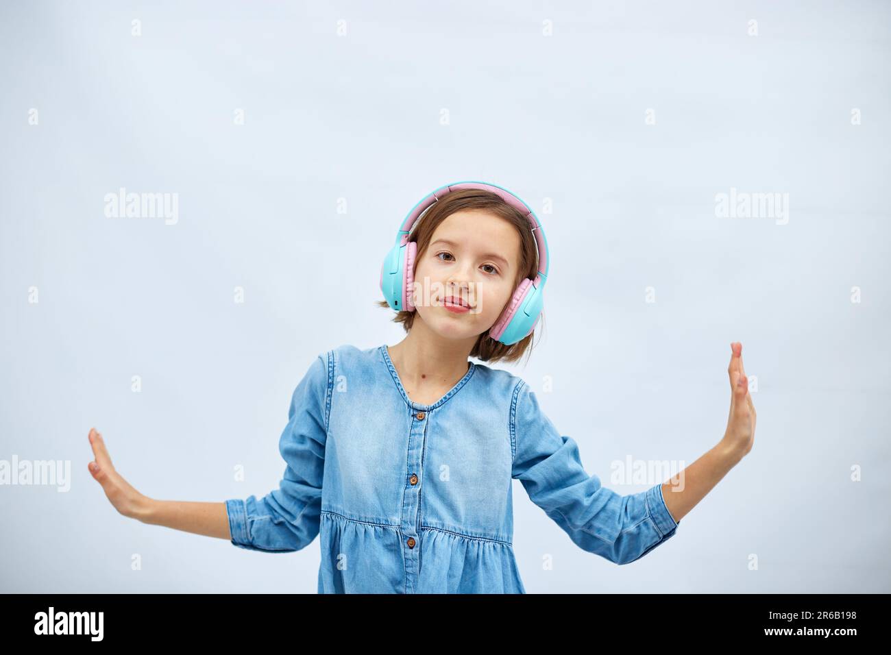 Girl teenager in casual denim dress listening to music in headphones on ...