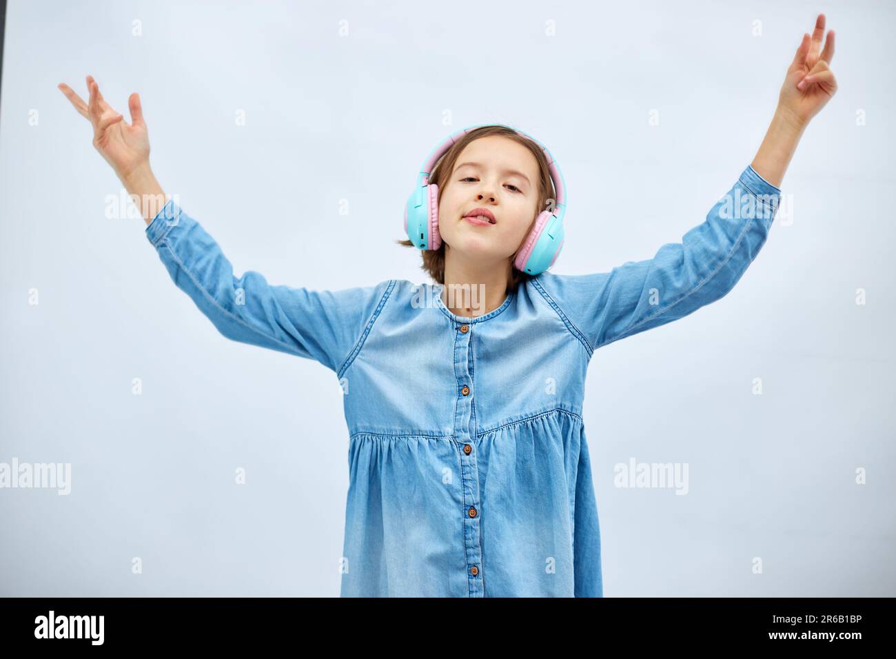 Girl teenager in casual denim dress listening to music in headphones on ...