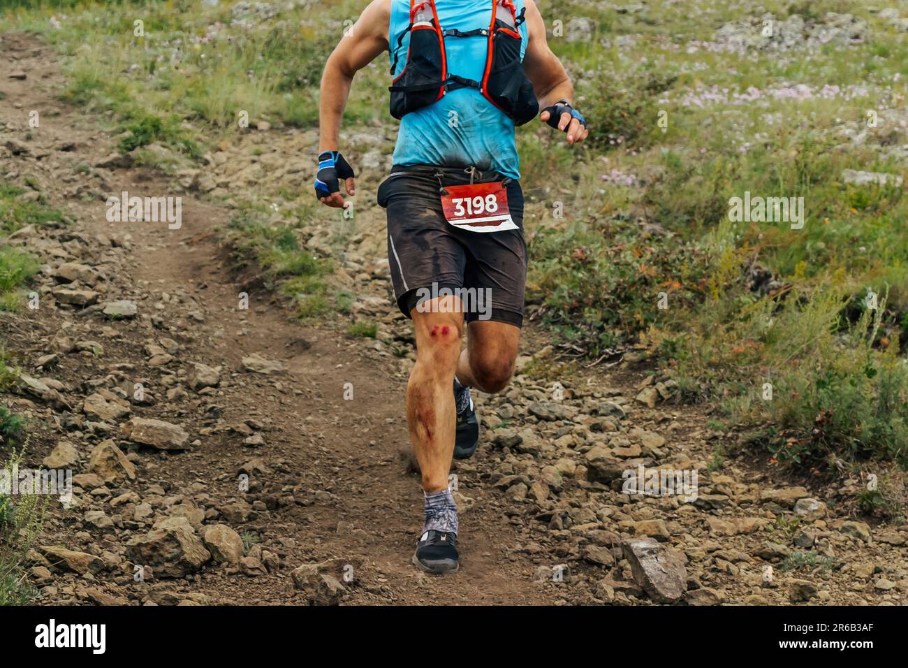 athlete runner running down mountain in trail marathon race, knee in ...
