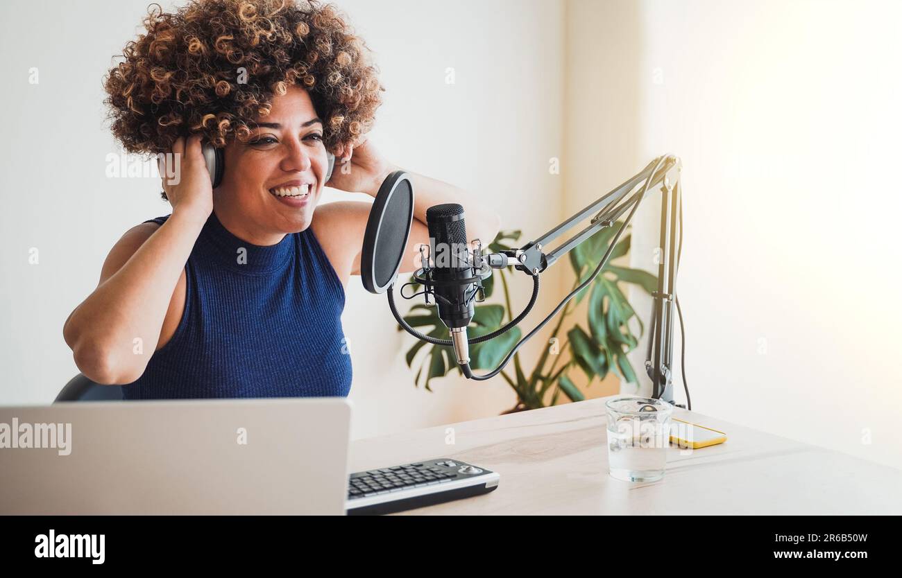 African host woman recording podcast at home studio - Business ...