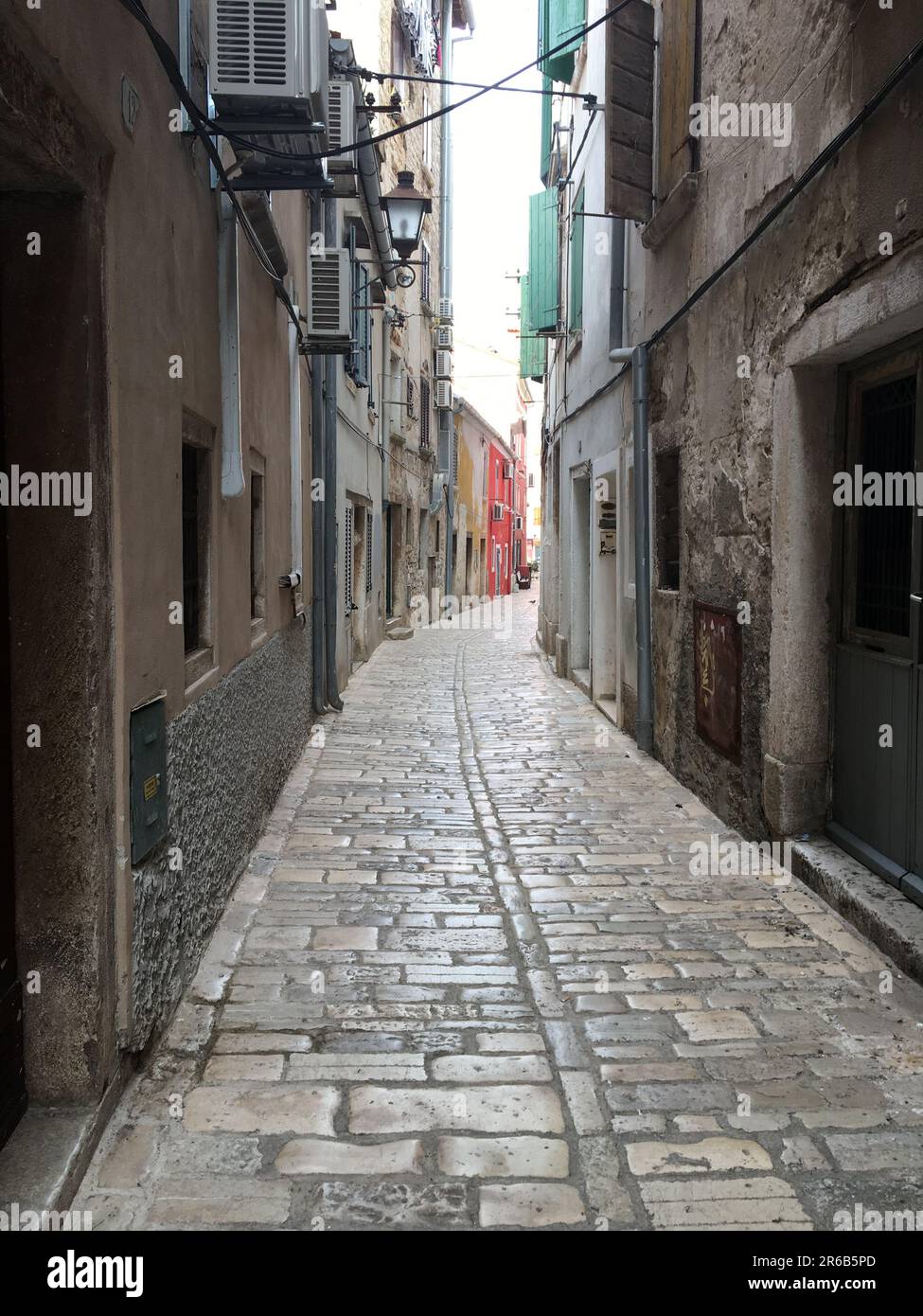 A picturesque alleyway between two buildings in a town or city, leading ...