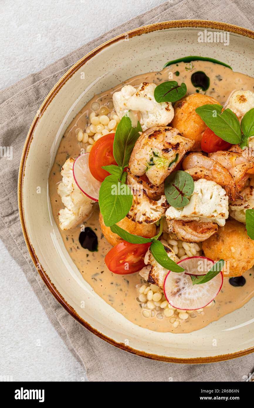 Portion of dish with ptitim and seafood Stock Photo - Alamy