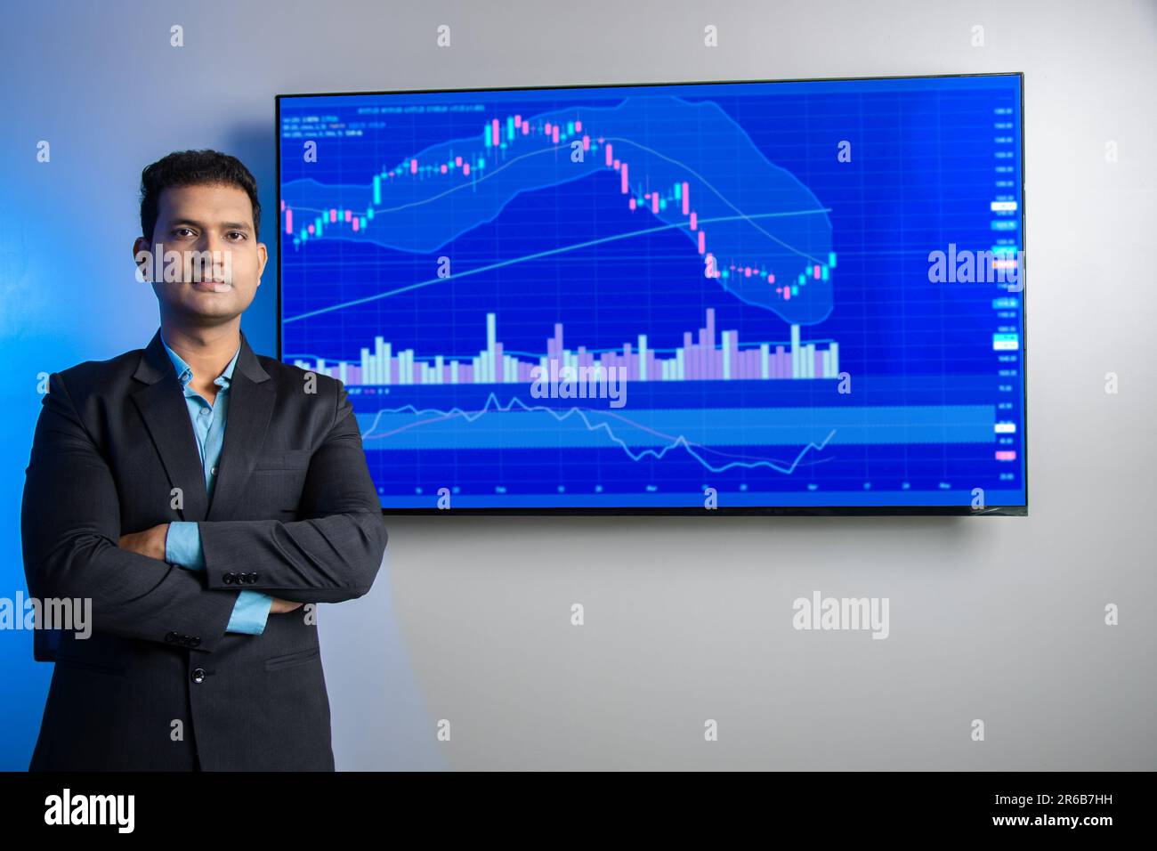 Portrait of indian businessman standing cross arms with stock market ...