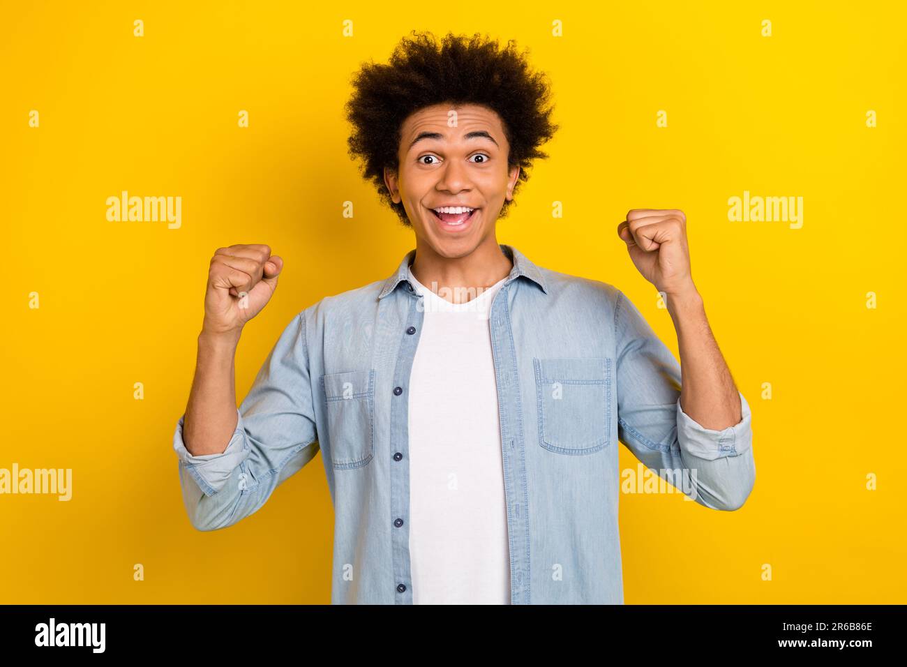 Photo of lucky cool guy dressed denim shirt rising fists screaming yeah ...
