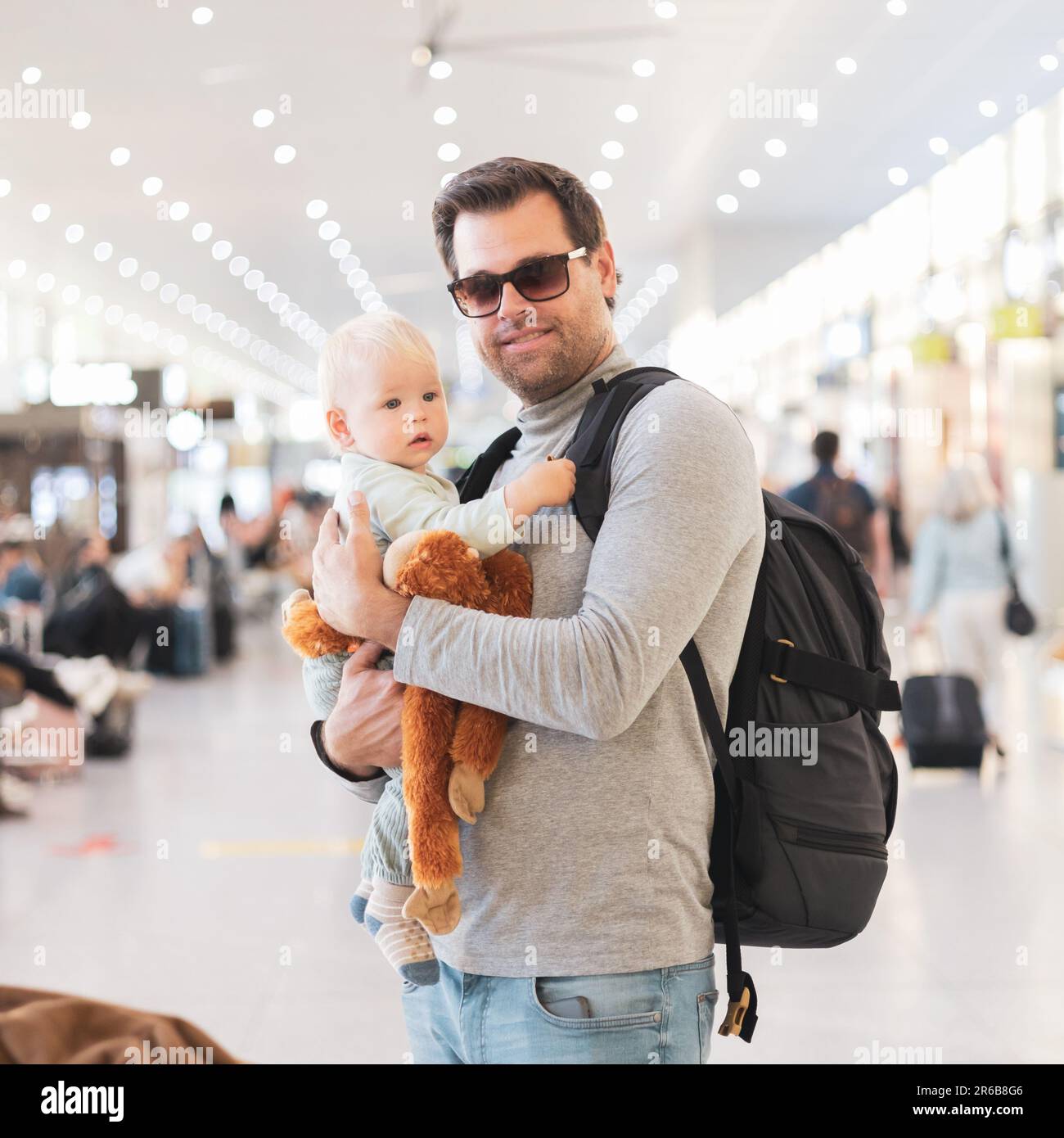 Father traveling with child, holding his infant baby boy at airport ...