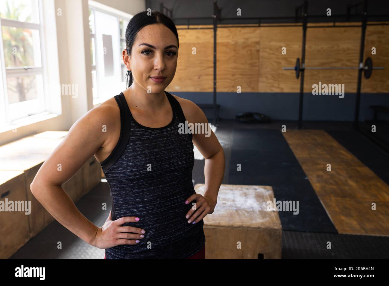 Portrait of confident caucasian young woman with hands on hip standing ...