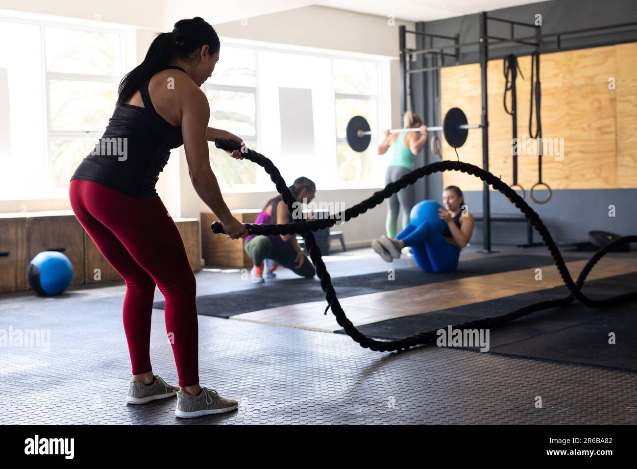 Side view of dedicated caucasian young woman exercising with battle ...