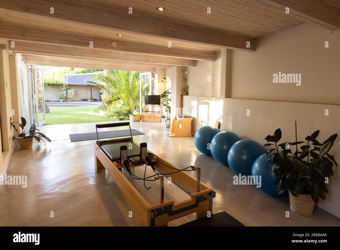 Interior of pilates studio with exercise equipment and plants Stock ...