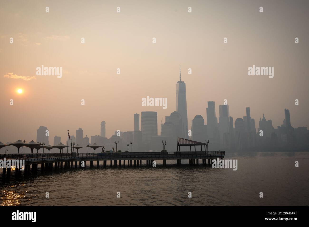 The sun rises behind the One World Trade Center, while the smoke from ...