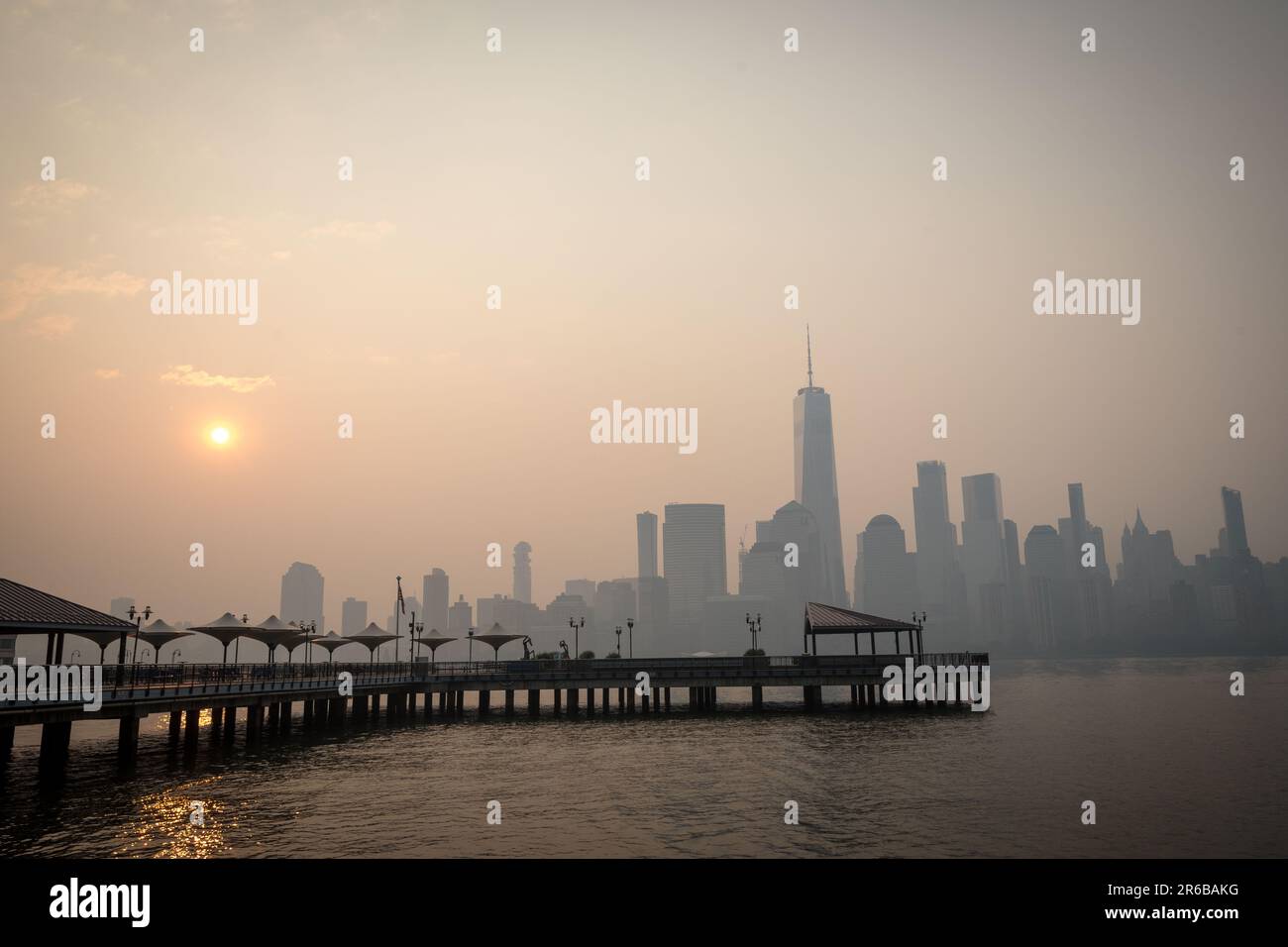 The sun rises behind the One World Trade Center, while the smoke from ...
