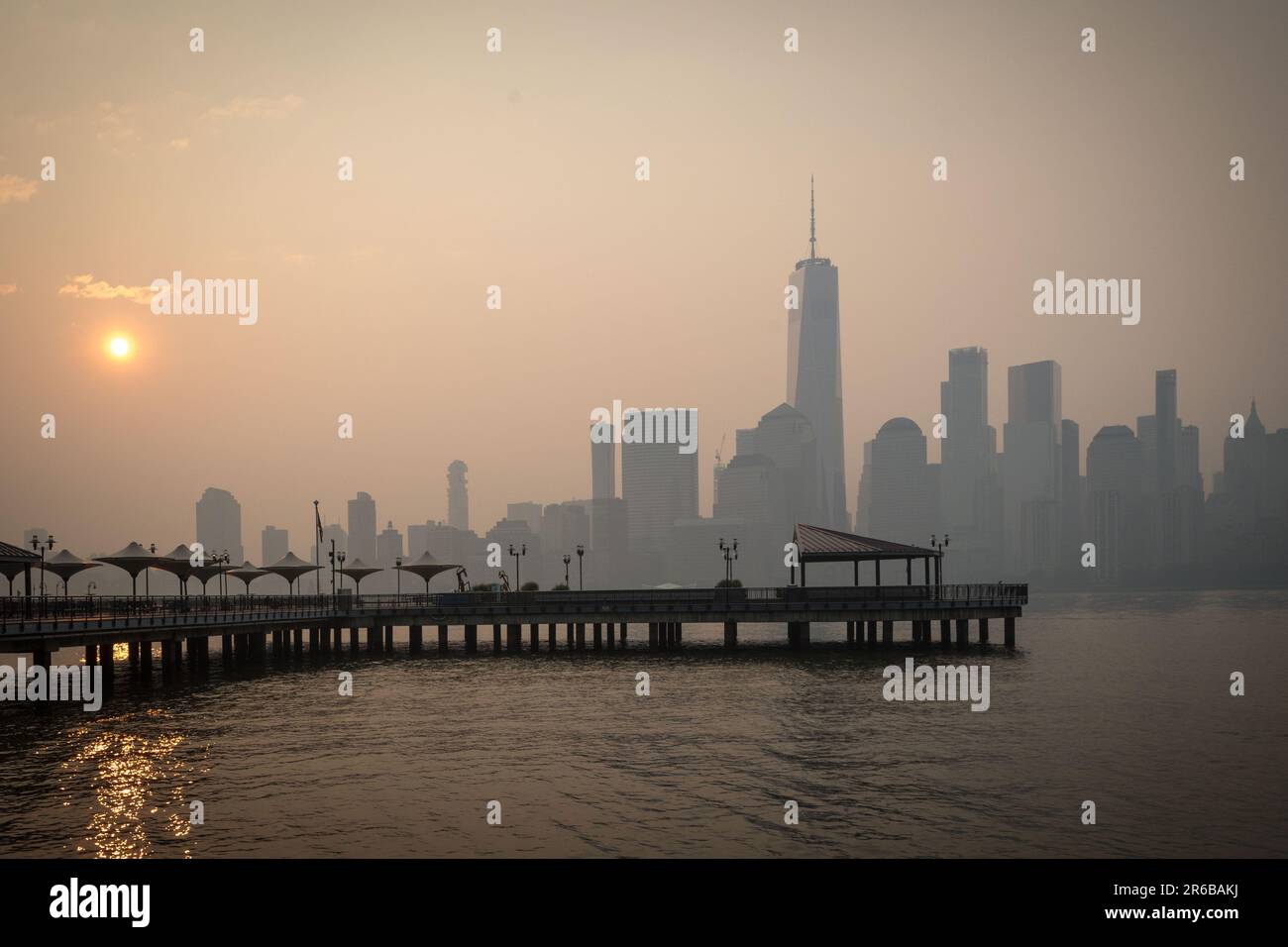 The sun rises behind the One World Trade Center, while the smoke from ...