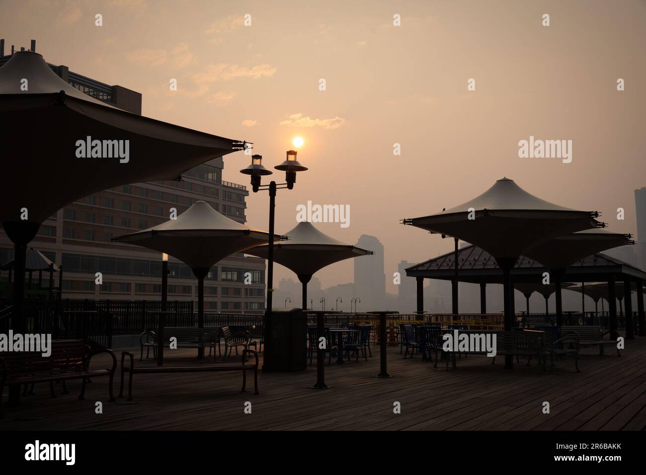 The sun rises behind the One World Trade Center, while the smoke from ...