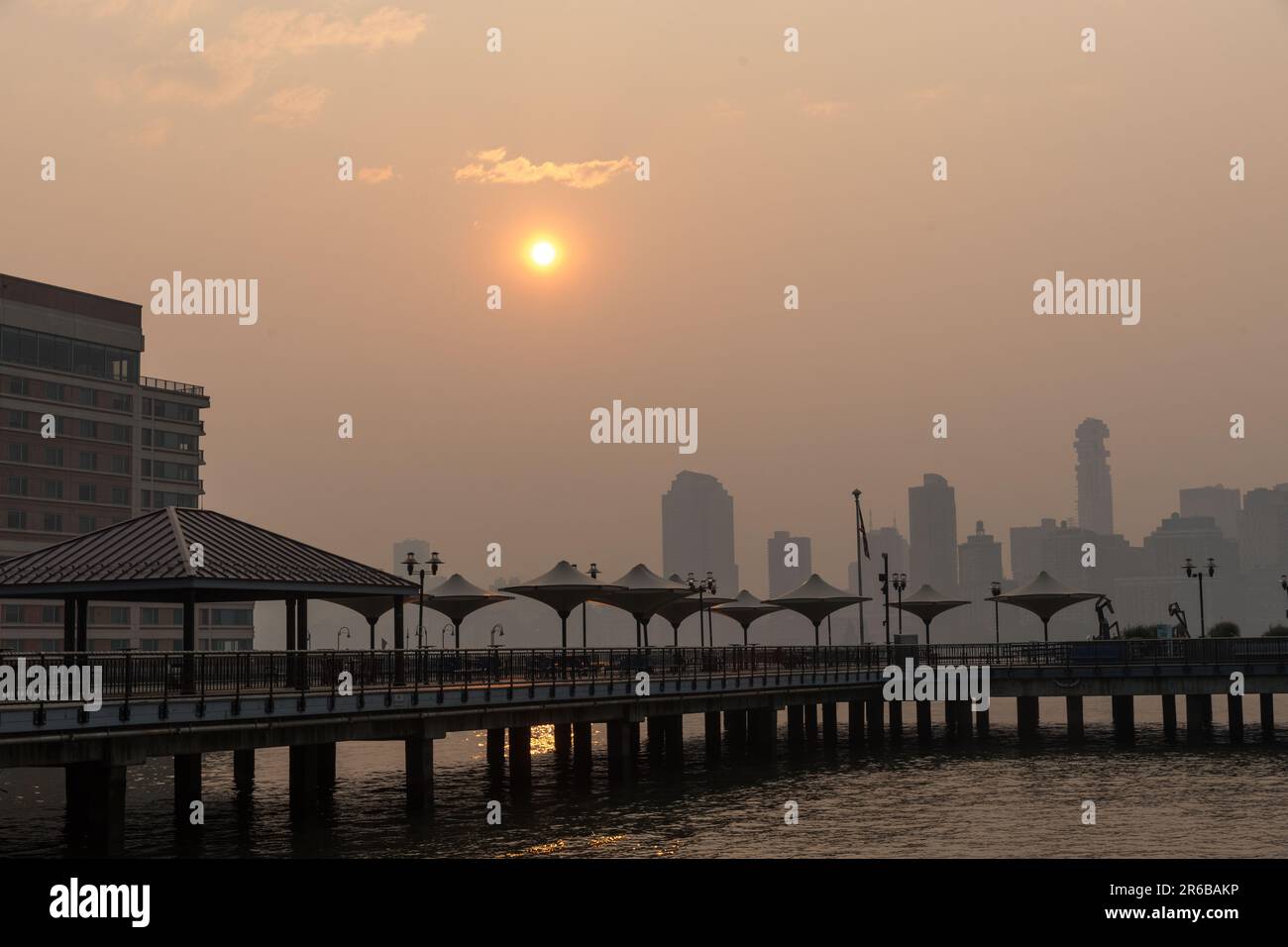 The sun rises behind the One World Trade Center, while the smoke from ...