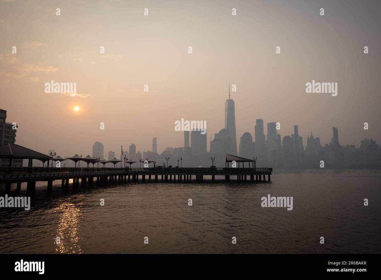 The sun rises behind the One World Trade Center, while the smoke from ...