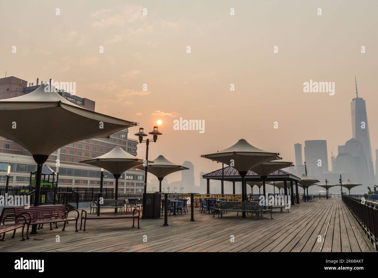 The sun rises behind the One World Trade Center, while the smoke from ...