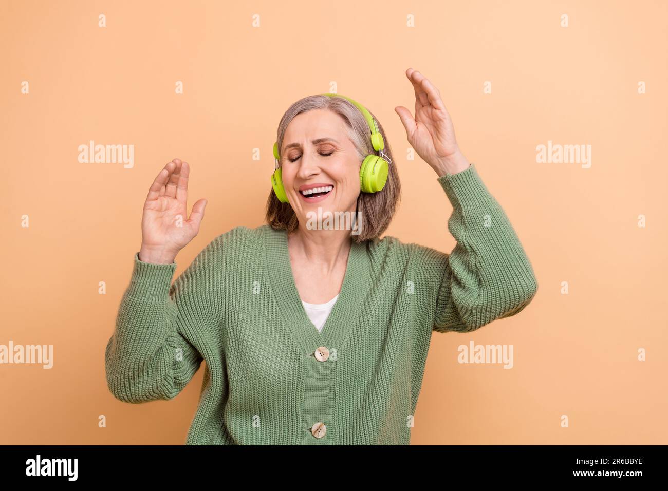 Photo of satisfied careless old lady wear khaki shirt listen energetic ...