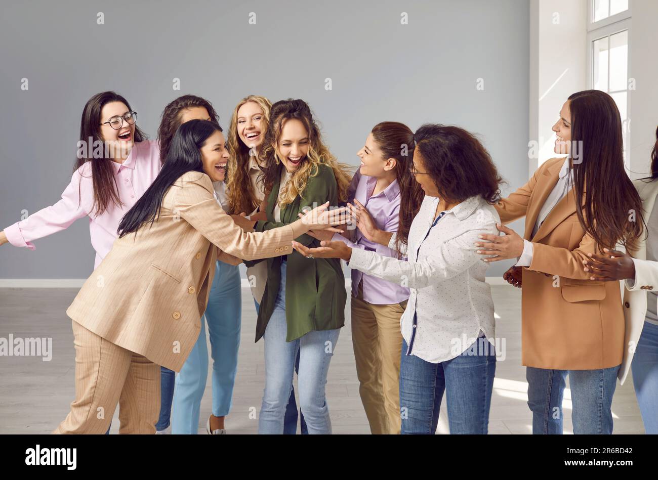 Team of happy diverse business women hugging and congratulating their ...