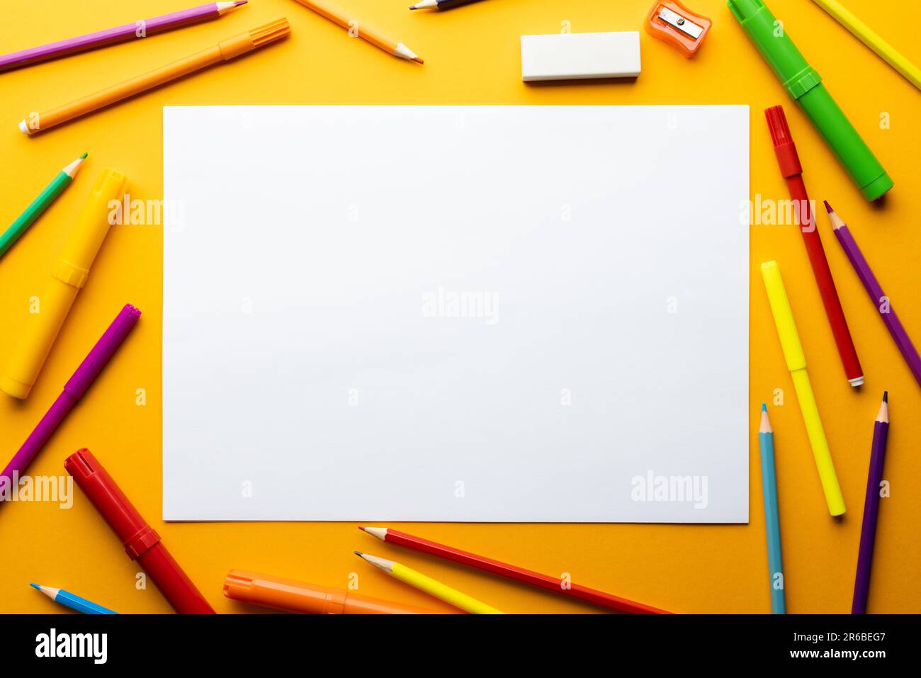 Flat lay of white paper with copy space and pens and markers on orange ...