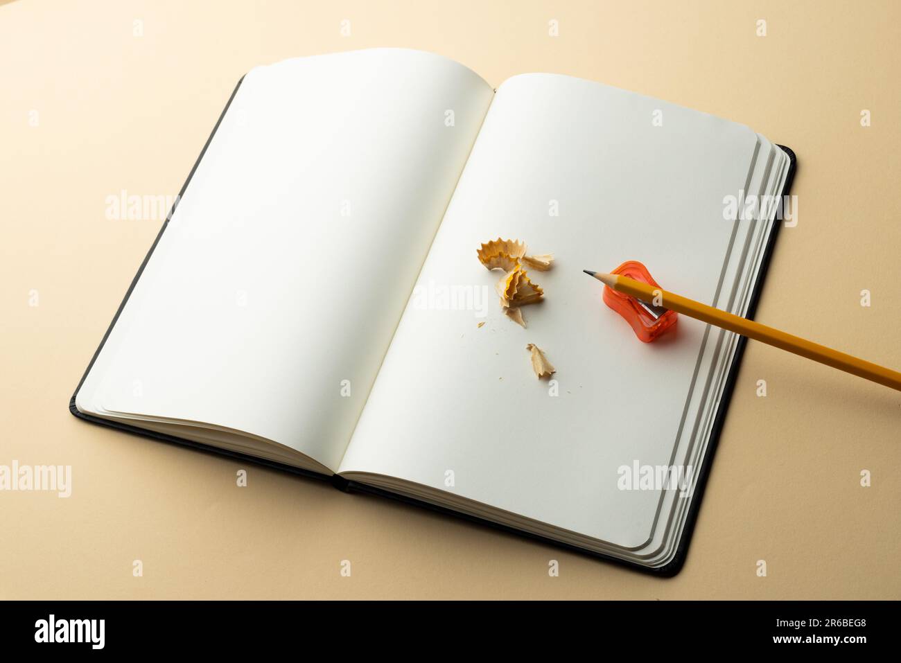 Close up of notebook and pencil, sharpener with copy space on yellow ...