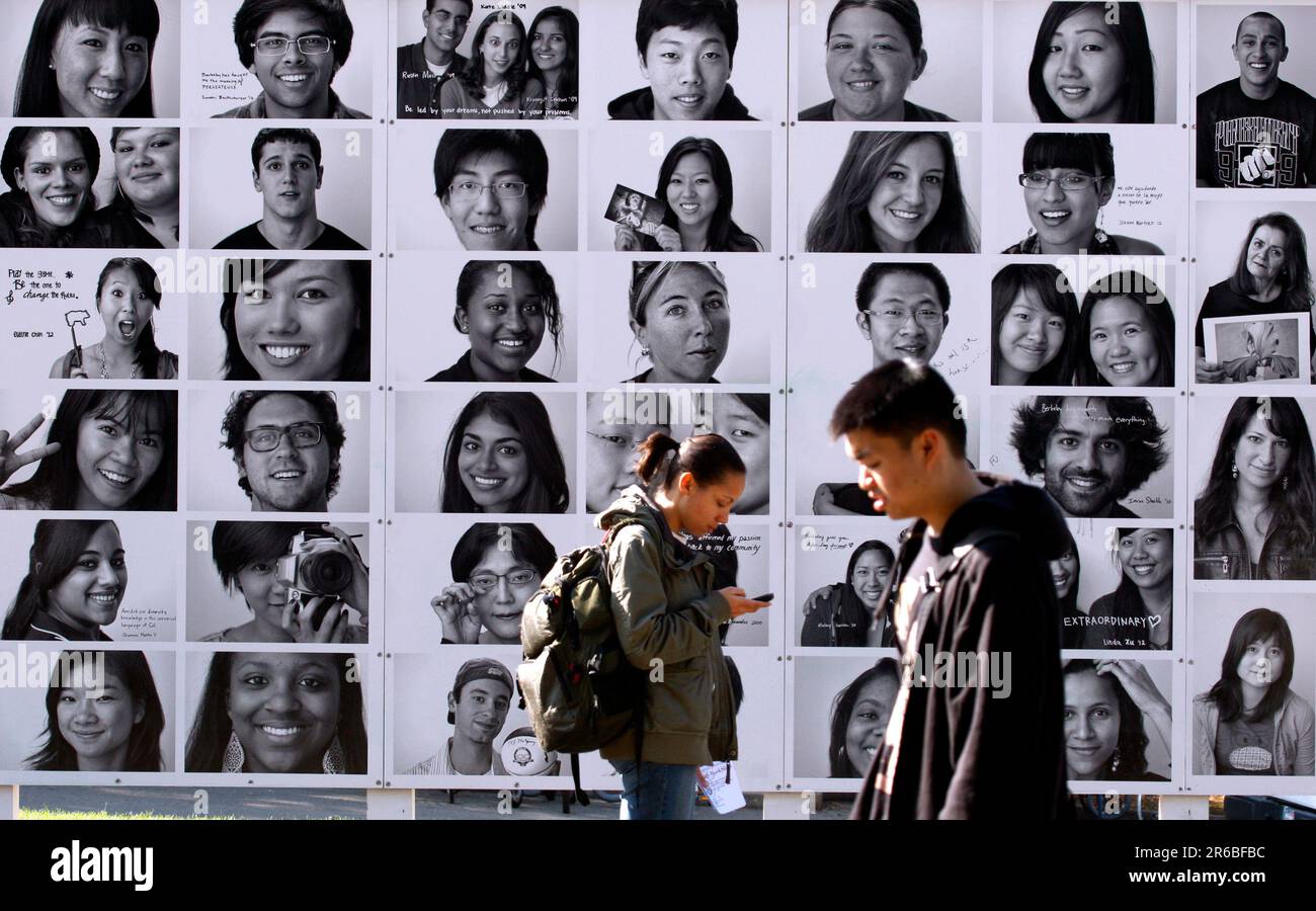 Students walk past a panel of photographs by photographer Christopher ...