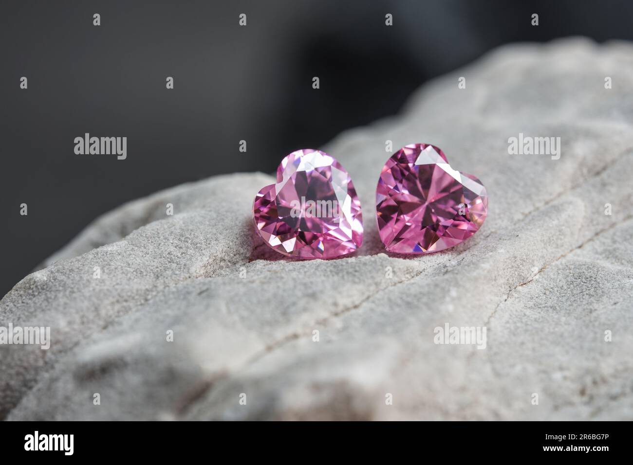 The glimmering natural heart shaped pink sapphire gemstones on a rugged ...
