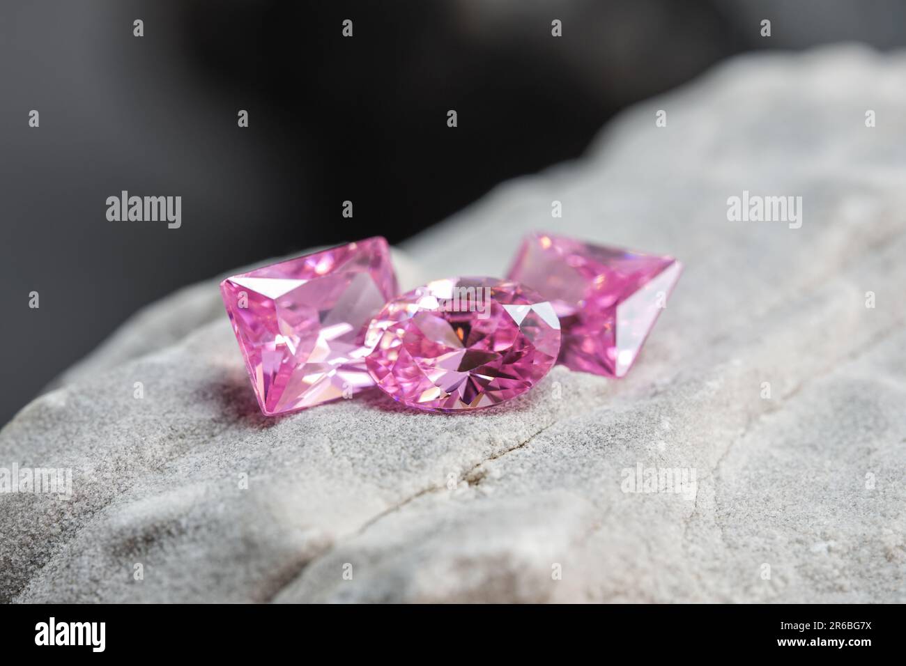 The glimmering natural pink sapphire gemstones on a rugged rock surface ...