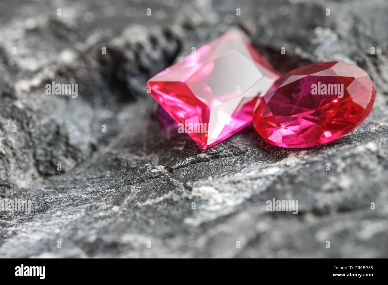 The glimmering natural pink sapphire gemstones on a rugged rock surface ...