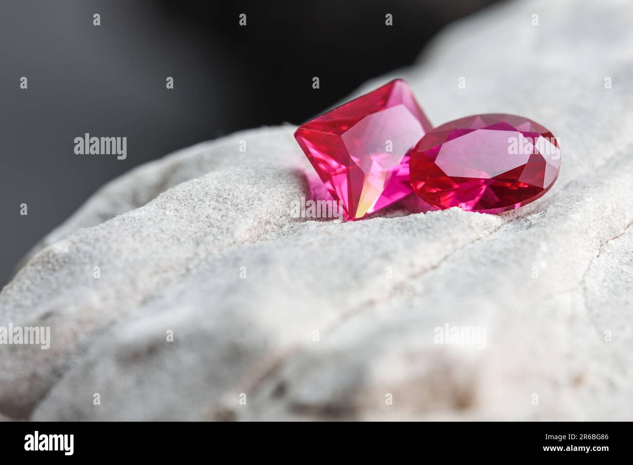 The glimmering natural pink sapphire gemstones on a rugged rock surface ...