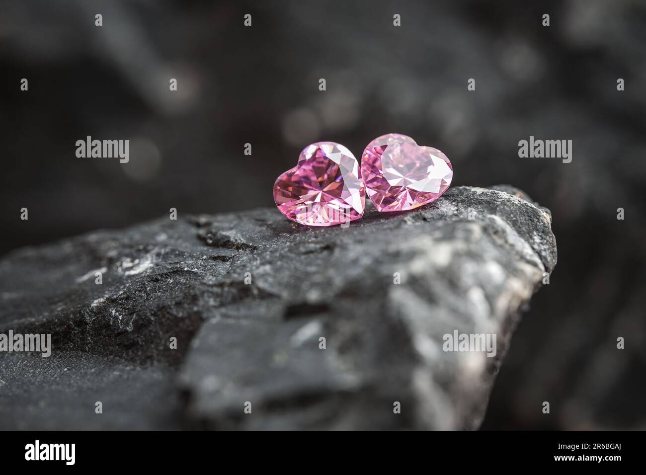 The glimmering natural heart shaped pink sapphire gemstones on a rugged ...