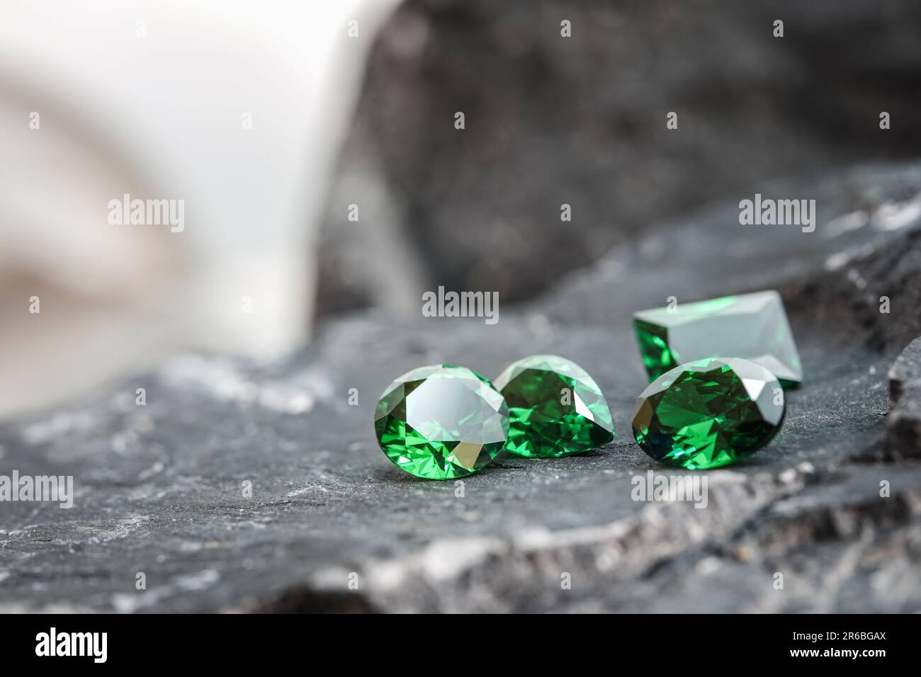 The glimmering natural green sapphire gemstones on a rugged rock ...