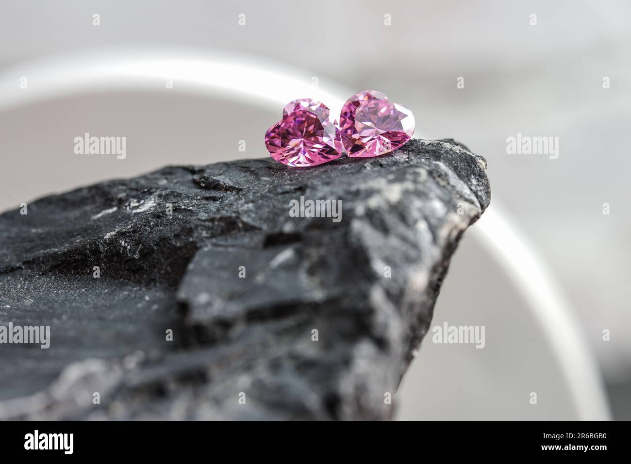 The glimmering natural heart shaped pink sapphire gemstones on a rugged ...