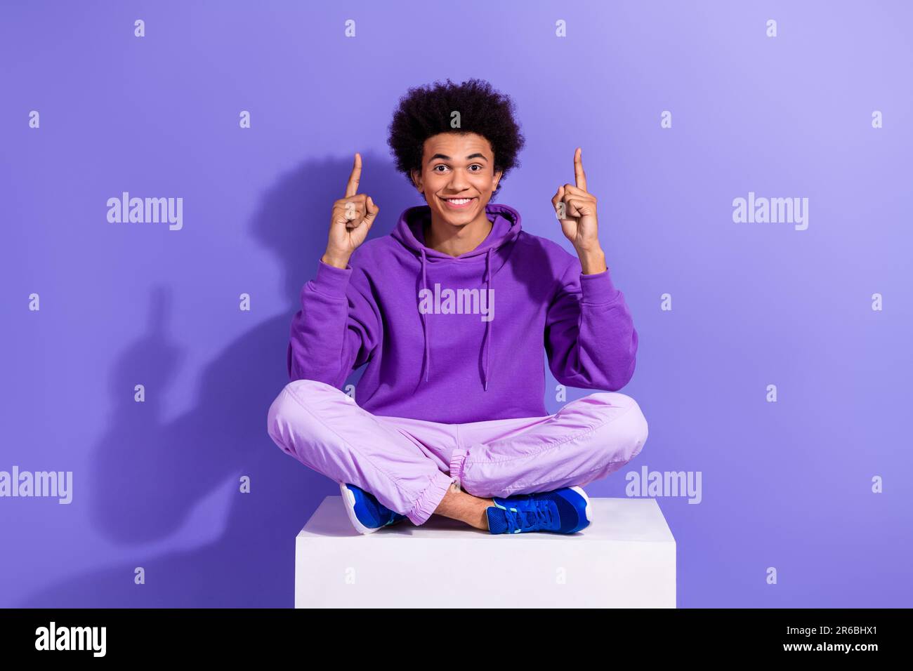 Full length photo of cheerful positive guy sit on white platform ...