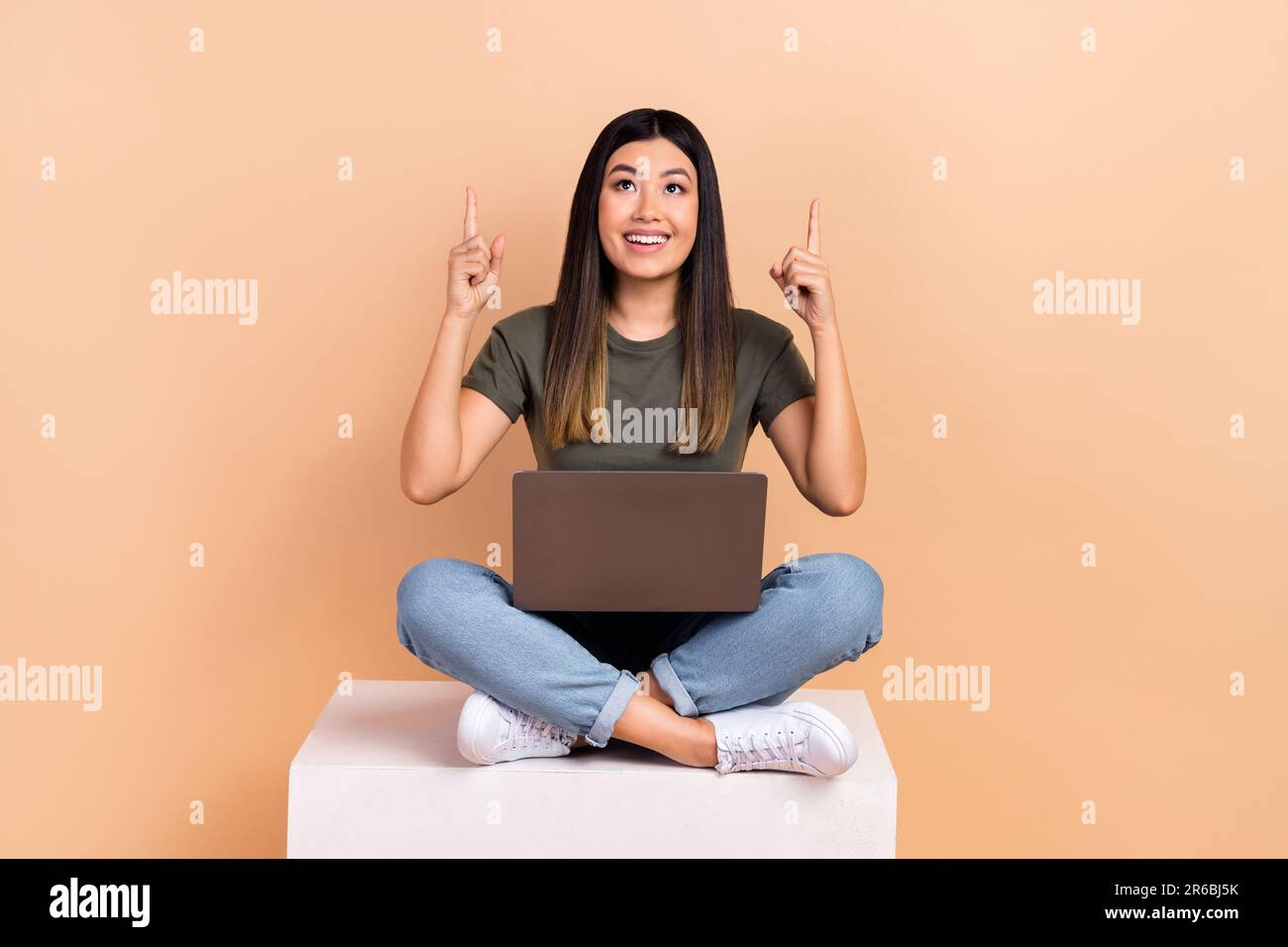 Full body cadre of young woman sit platform indicate fingers look copyspace promo netbook store ...