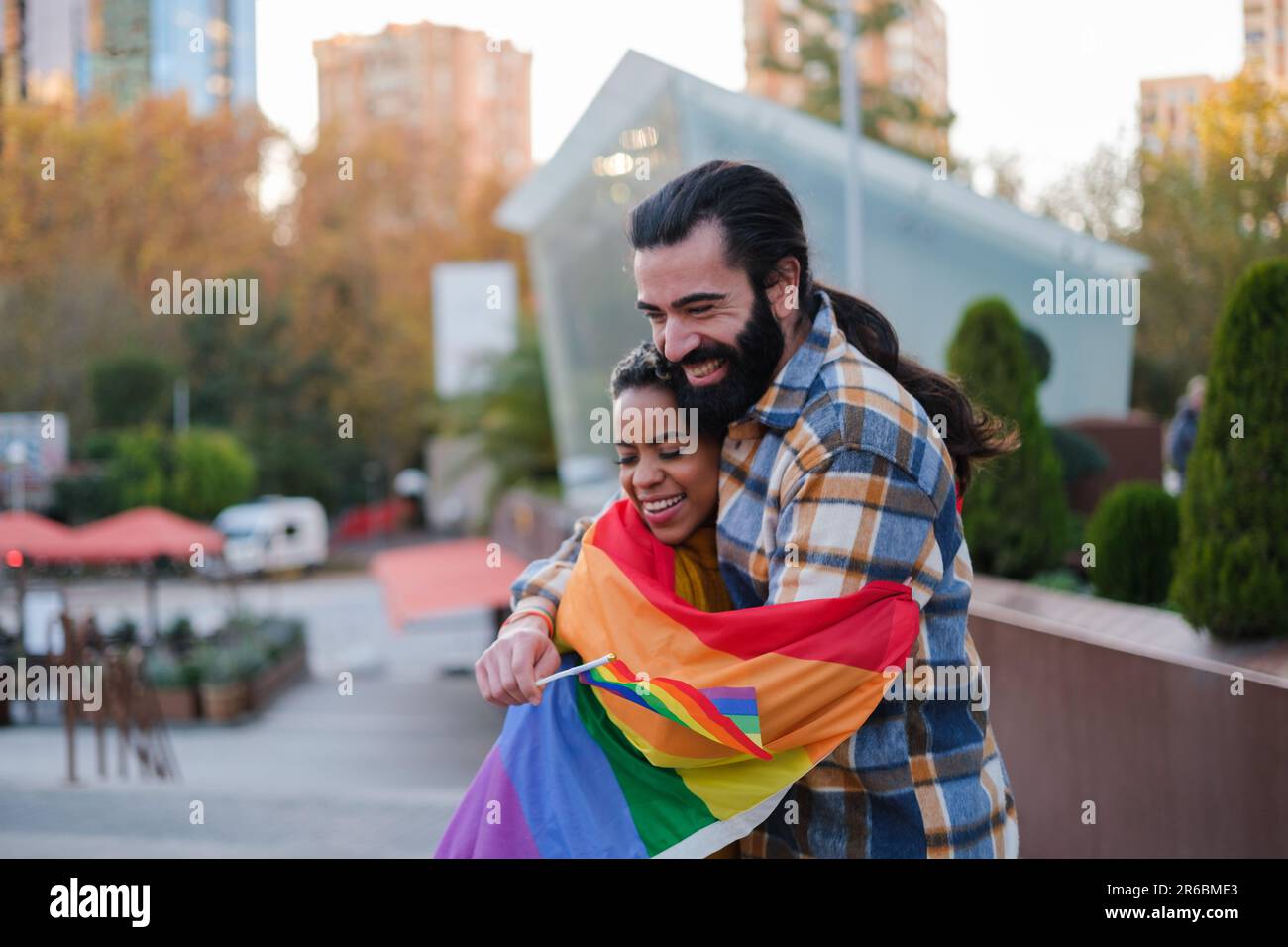 Young couple embracing s with a lgtbi rainbow flag. Concept: lifestyle ...